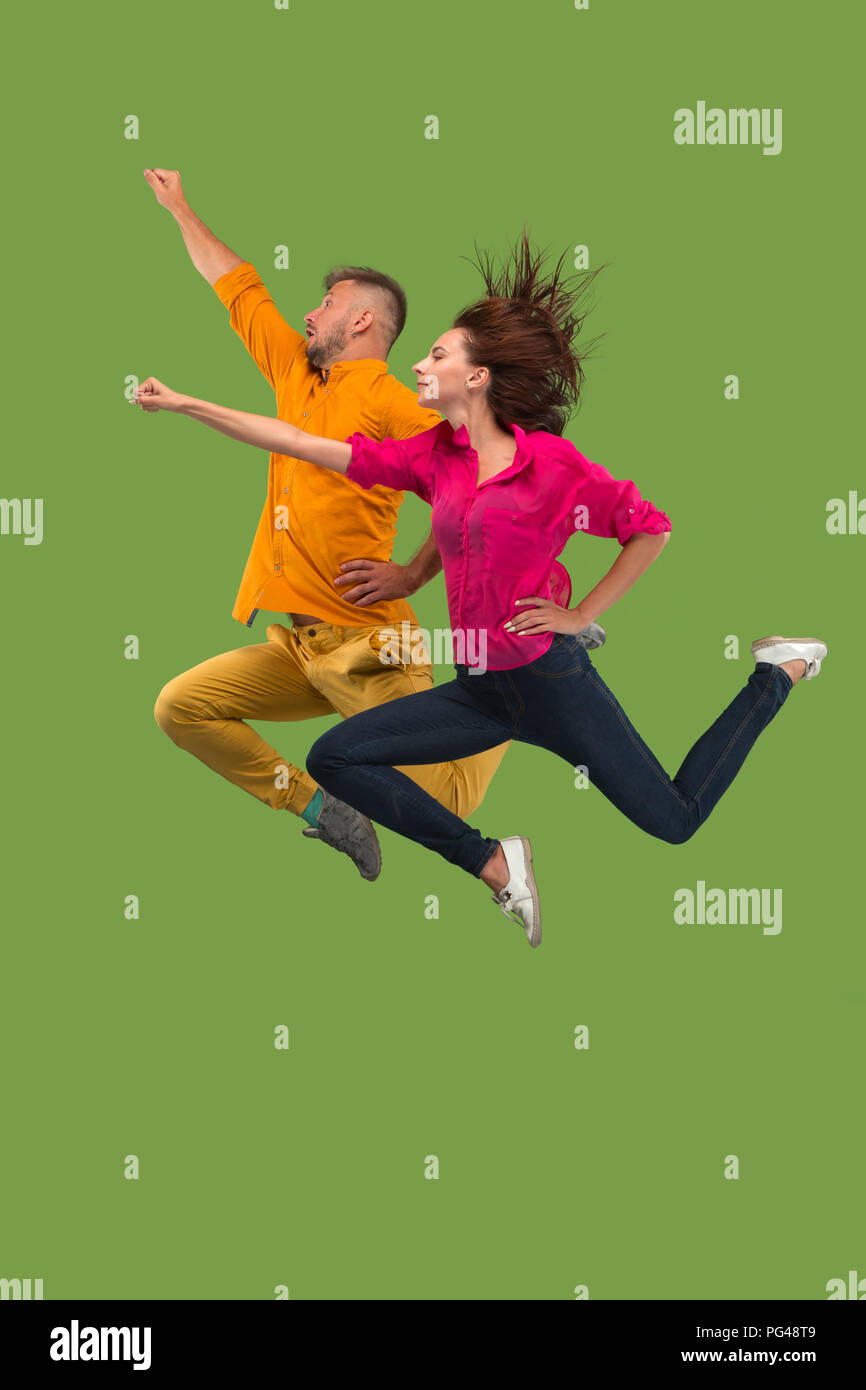 Freedom in moving and forward motion. The happy young couple jumping ...