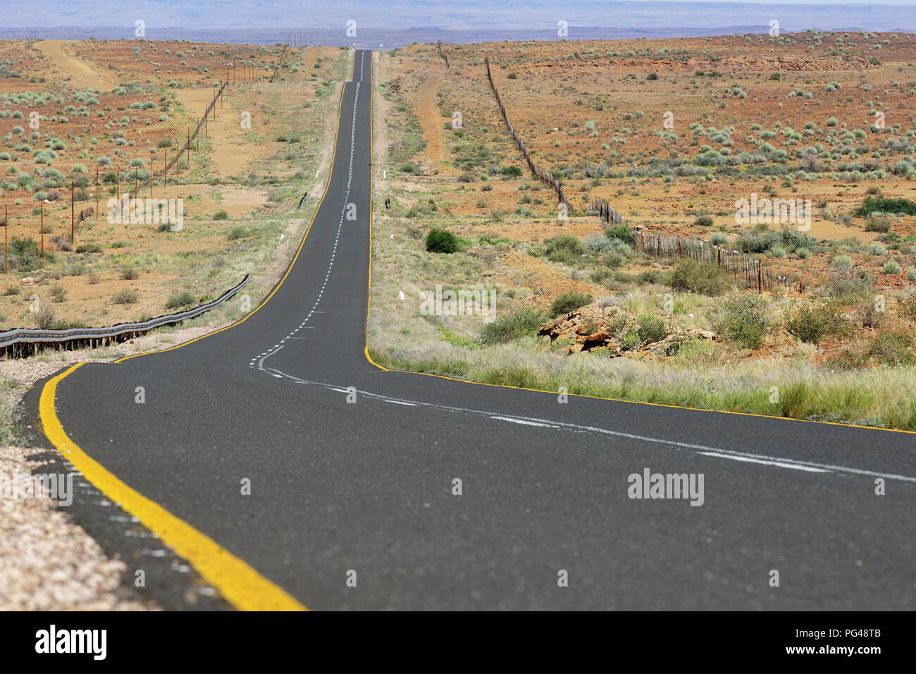 Long stretch of straight blacktop highway through the Namibian Desert ...