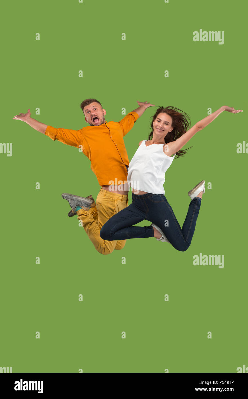 Freedom in moving and forward motion. The happy young couple jumping a ...