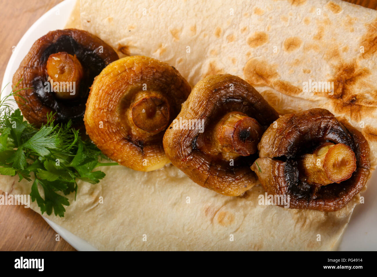 Grilled champignons with bread lavash Stock Photo - Alamy