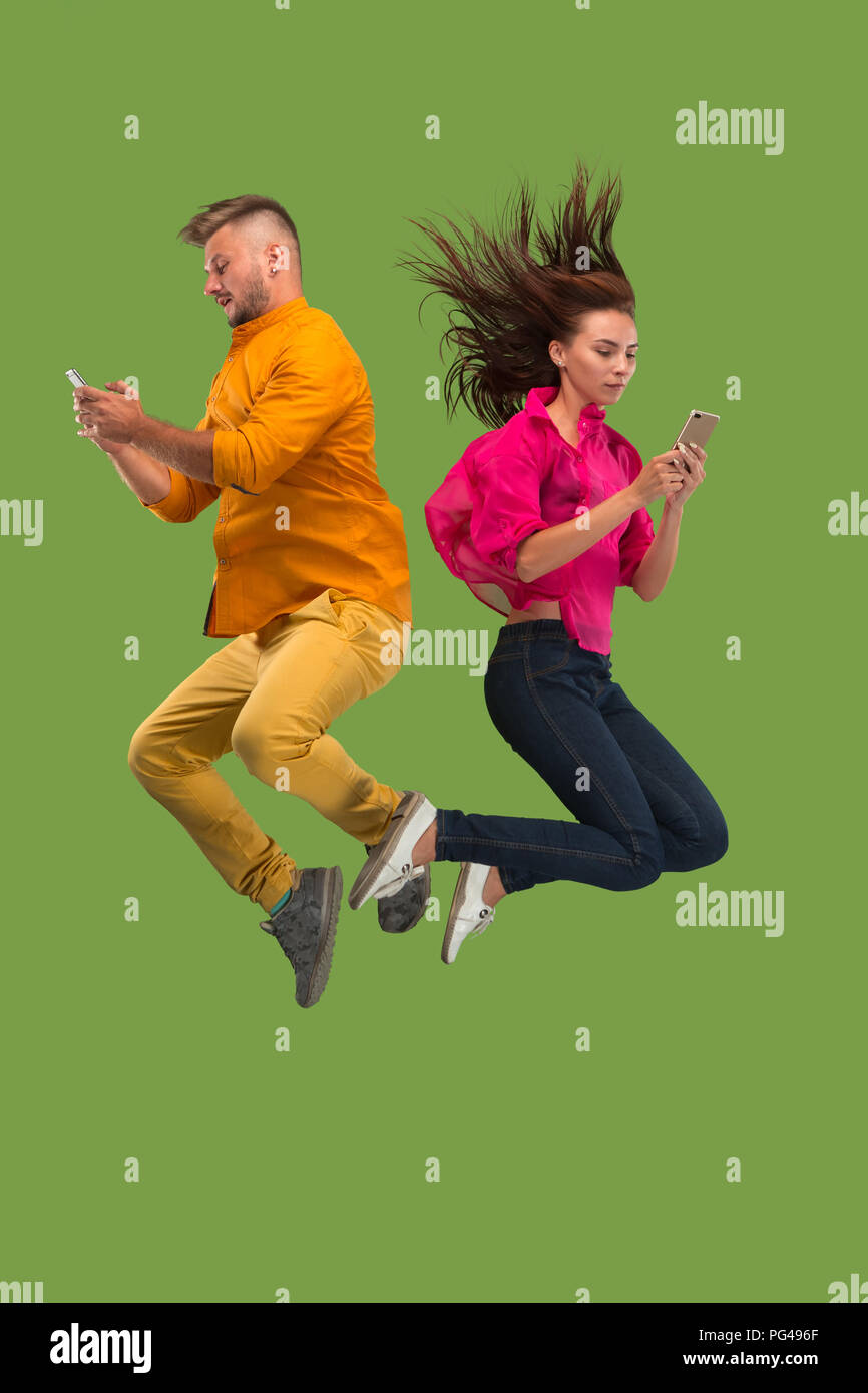 always on mobile. Full length of young couple taking phones while ...