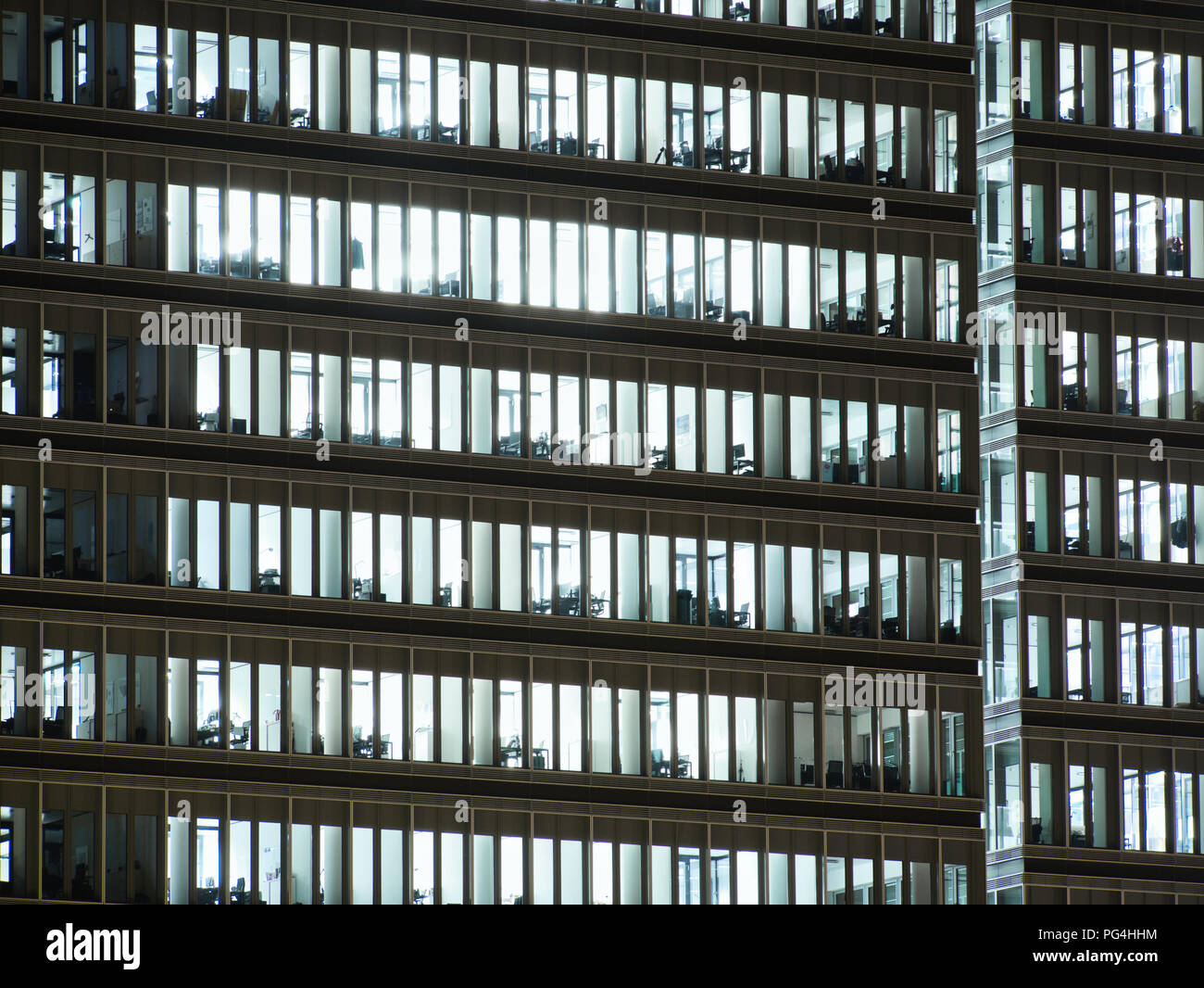 Windows of white lit offices in tall Office building viewed from ...