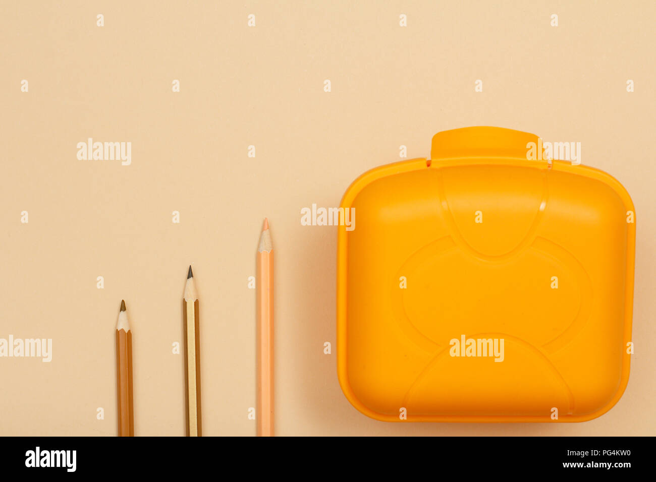 School supplies. Color pencils and lunch box on beige background. Top ...