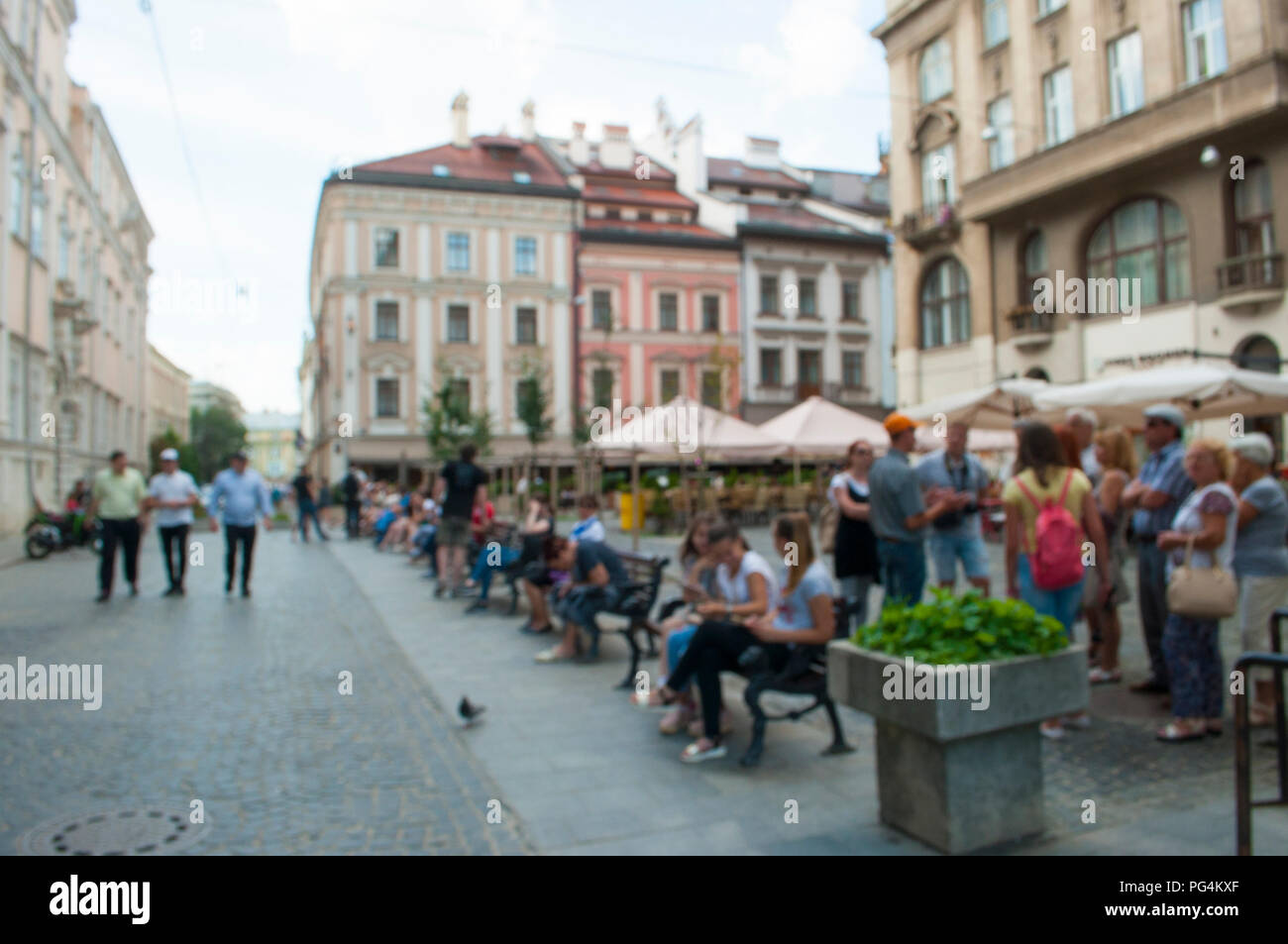 Blurred view of an old european square filled with people in a small ...