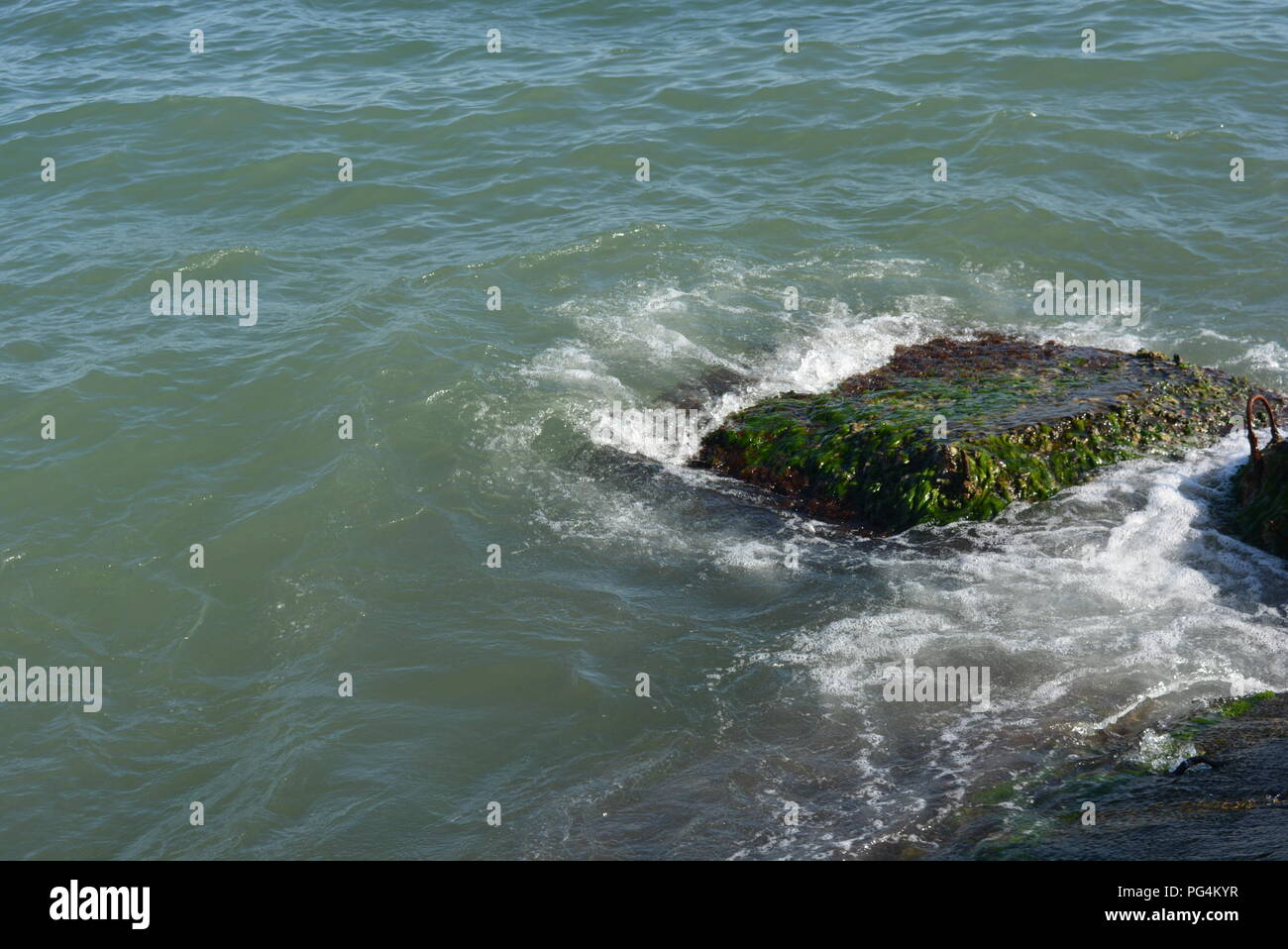 Unusual color of the black sea with a large stone and reinforced ...
