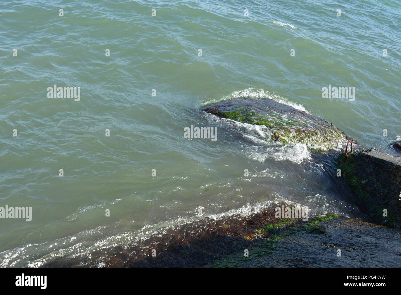 Unusual color of the black sea with a large stone and reinforced ...