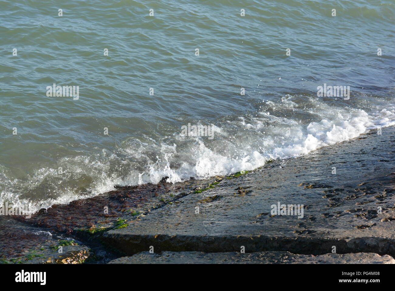 Unusual color of the black sea with a large stone and reinforced ...