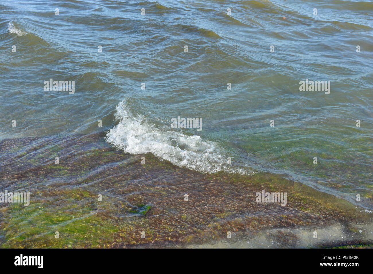 Unusual color of the black sea with a large stone and reinforced ...