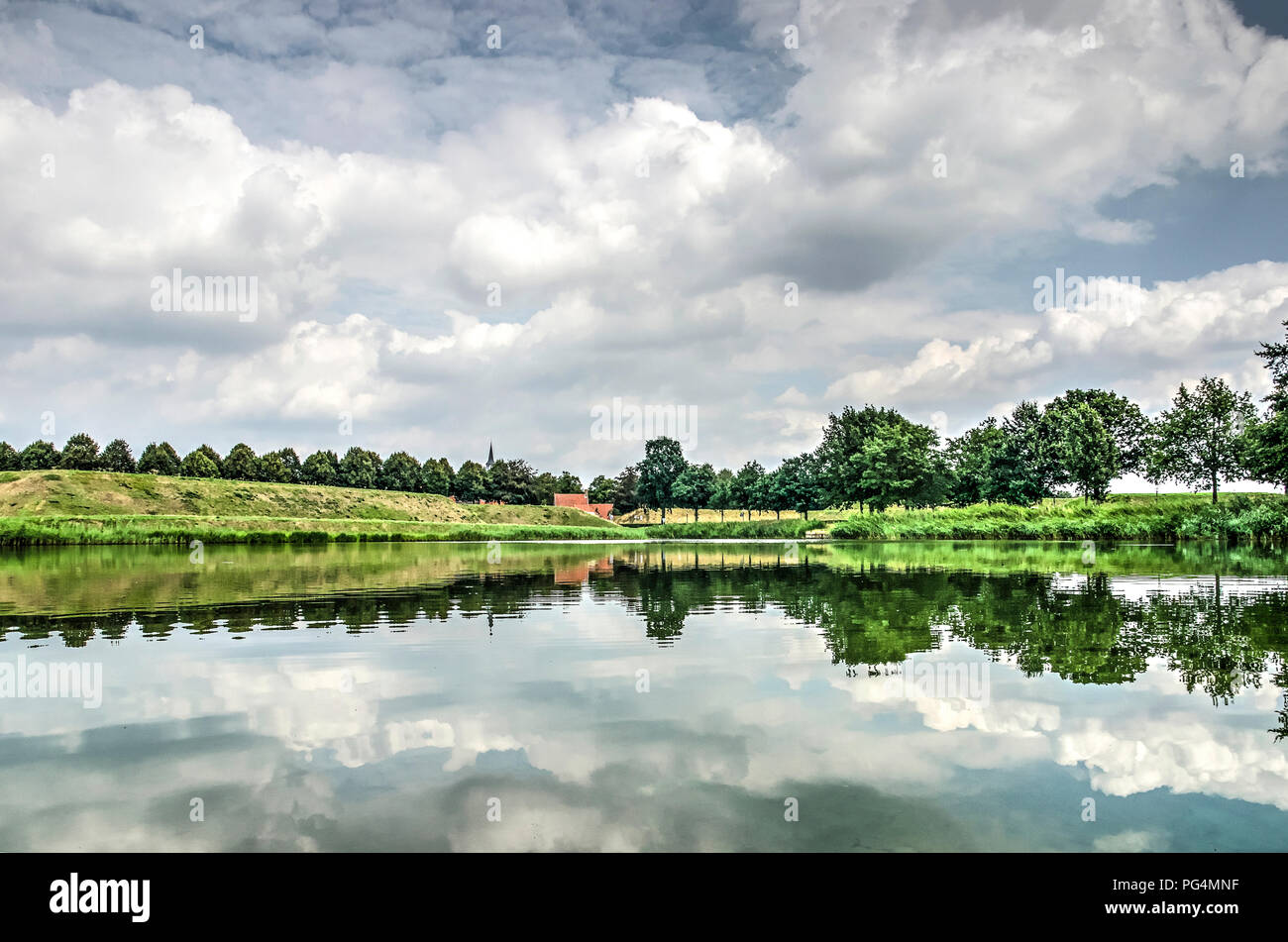 Dramatic cloudy sky reflecting in the calm water of one of the moats ...