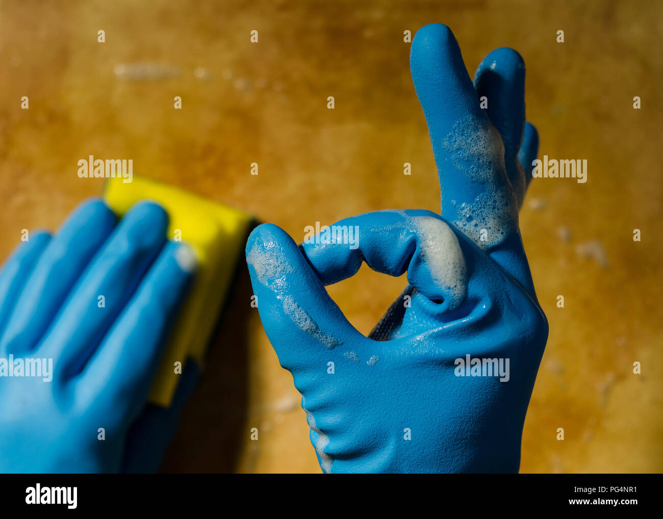 hands in rubber gloves cleaning the surfaces of ceramic tiles, safe and ...