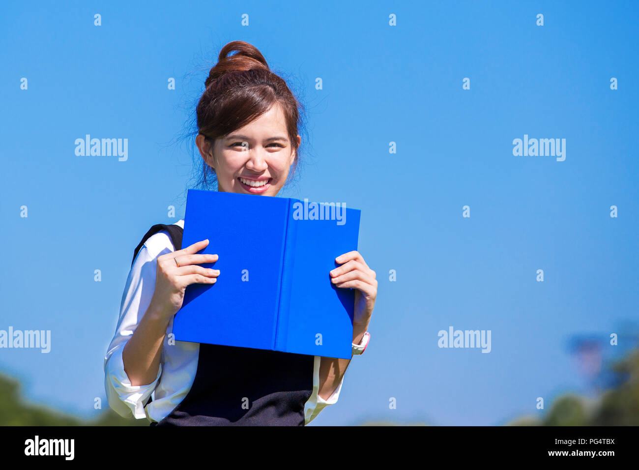 portrait of happy and smile asian female student with book in park of ...