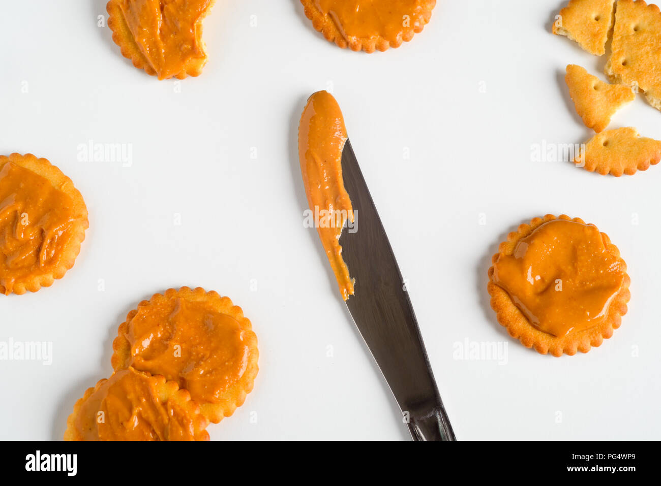 Tasty crackers with peanut butter, close-up. Knife, white minimalist ...