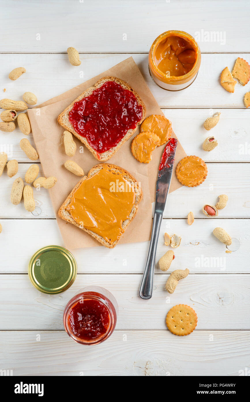 Traditional sandwich, peanuts, jam jar, crackers and knife, top-view ...