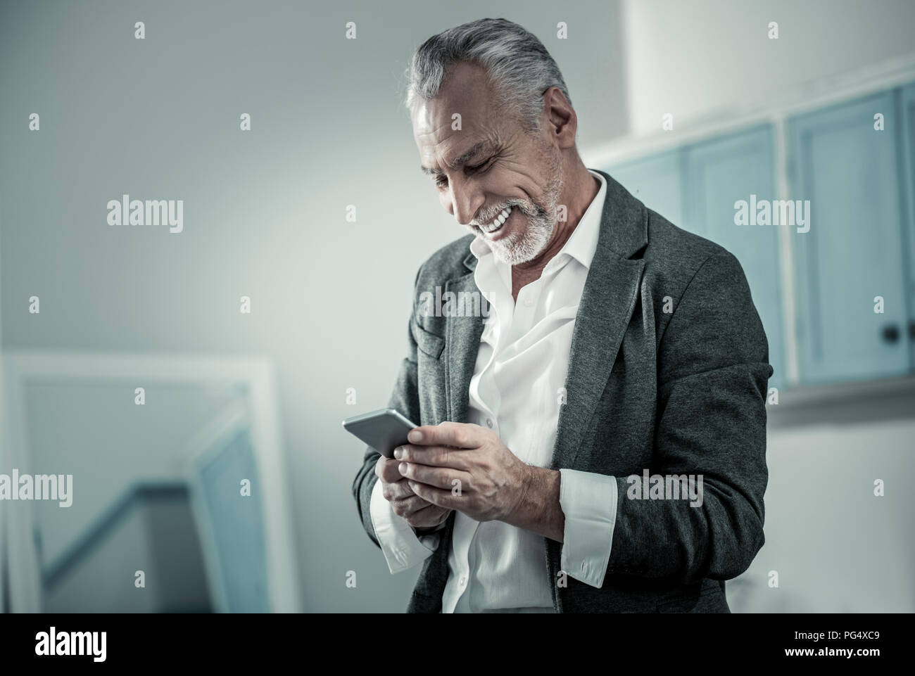 Happy bearded retirement reading message Stock Photo - Alamy