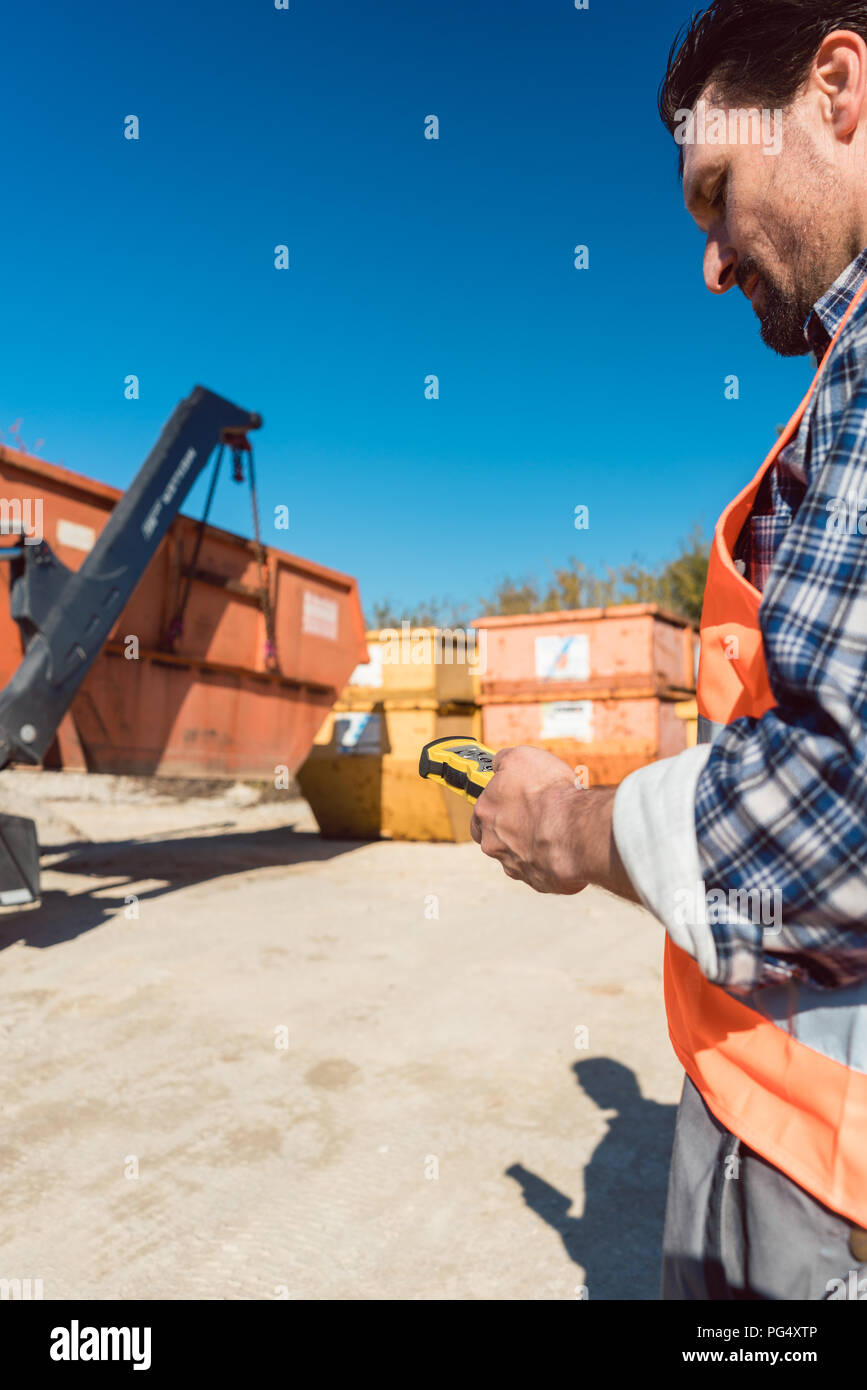 Man loading of construction debris container on truck Stock Photo - Alamy