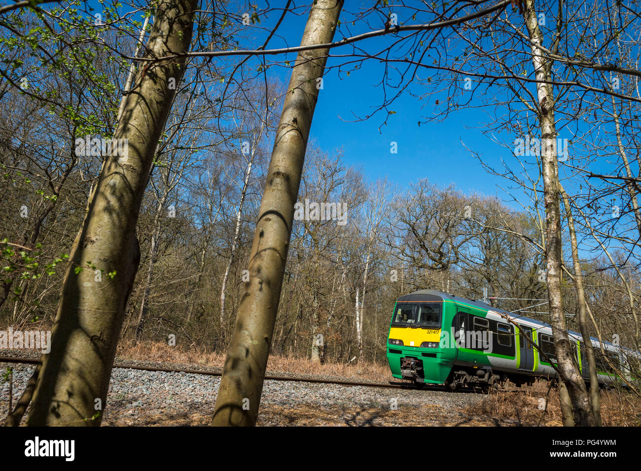 Class 321 passenger train in London Midland livery travelling along ...