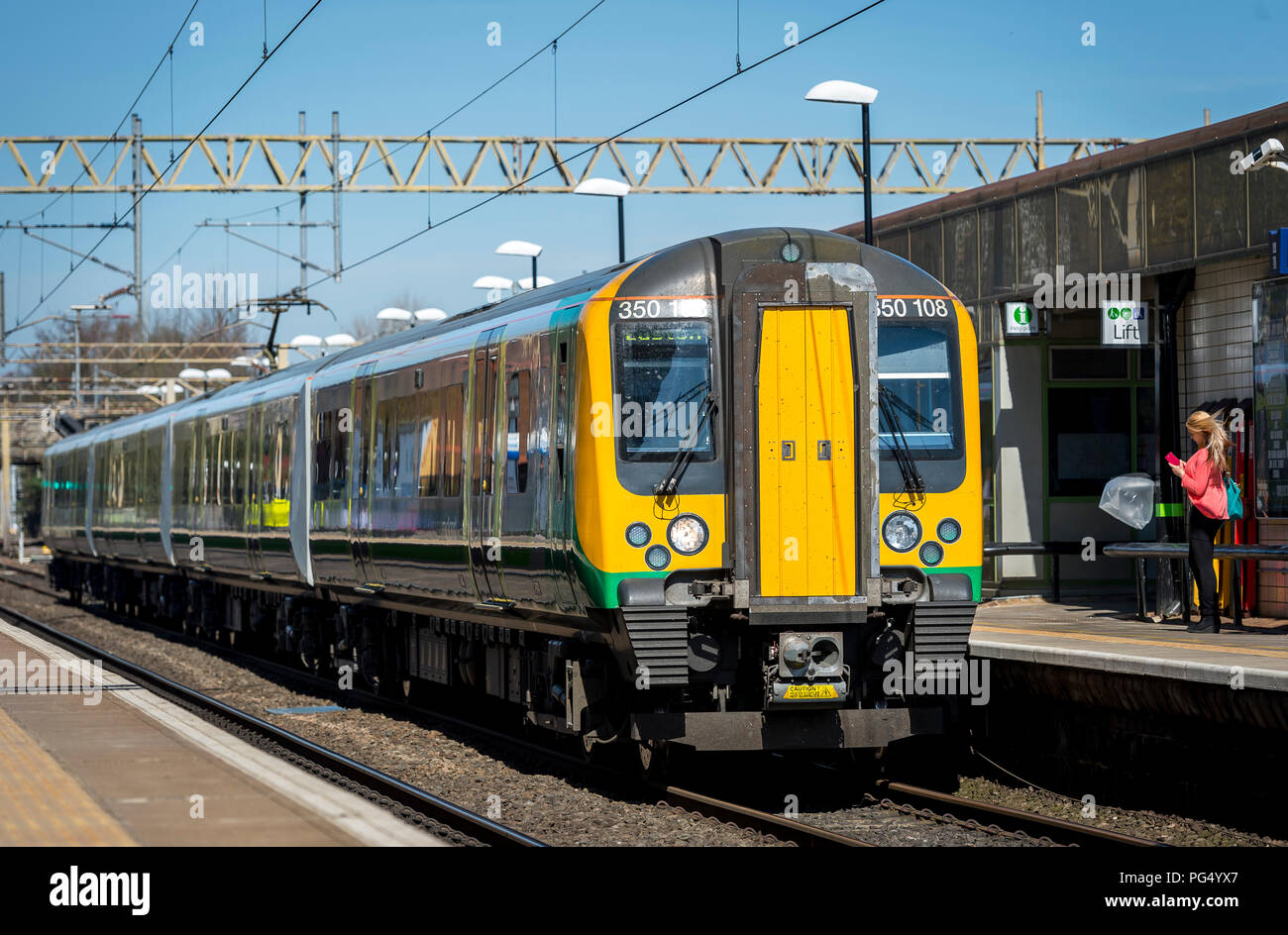 London Midland trains passenger train class 350 travelling at a station on the Abbey Line ...