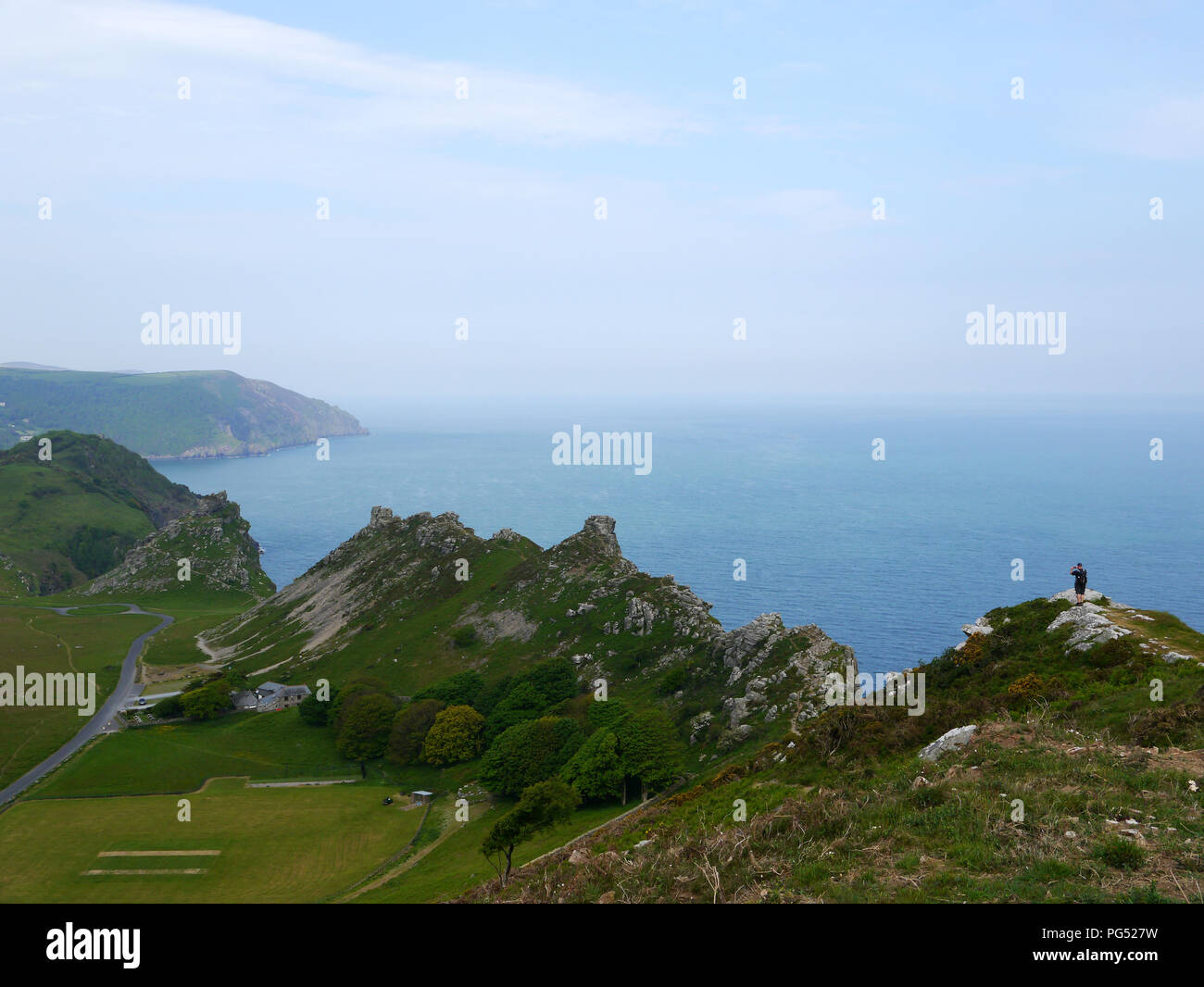Man Standing Taking Photo of Castle Rock and the Valley of Rocks from ...