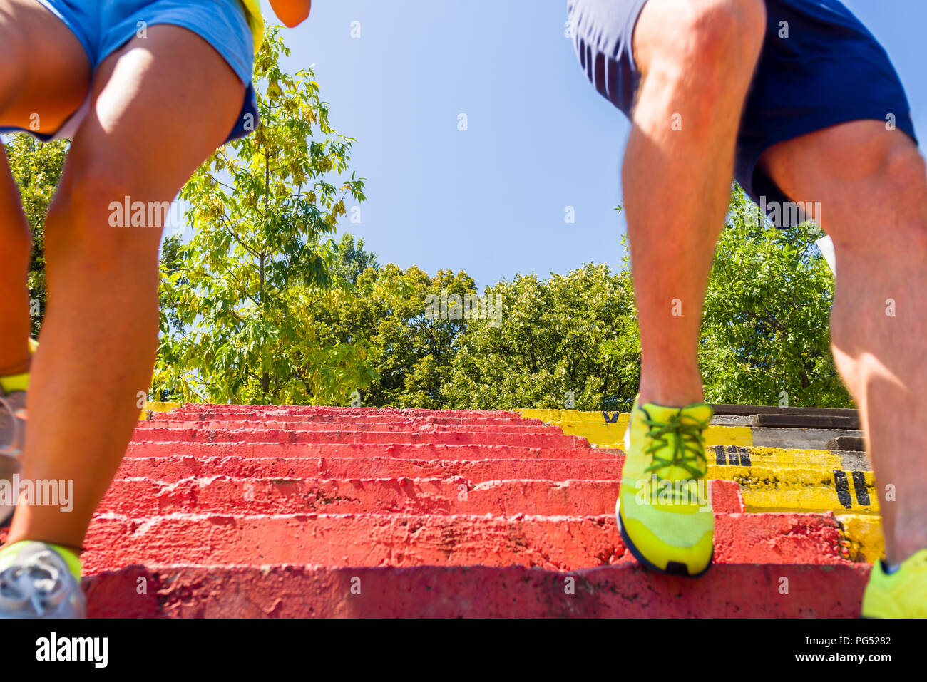 Fitness couple with muscular legs running through stairs Stock Photo ...