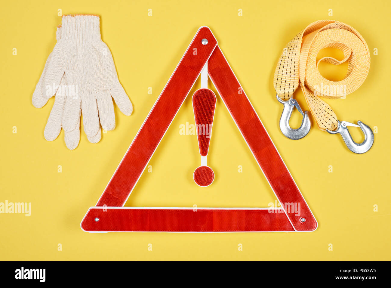top view of warning triangle road sign, gloves and car tow rope ...