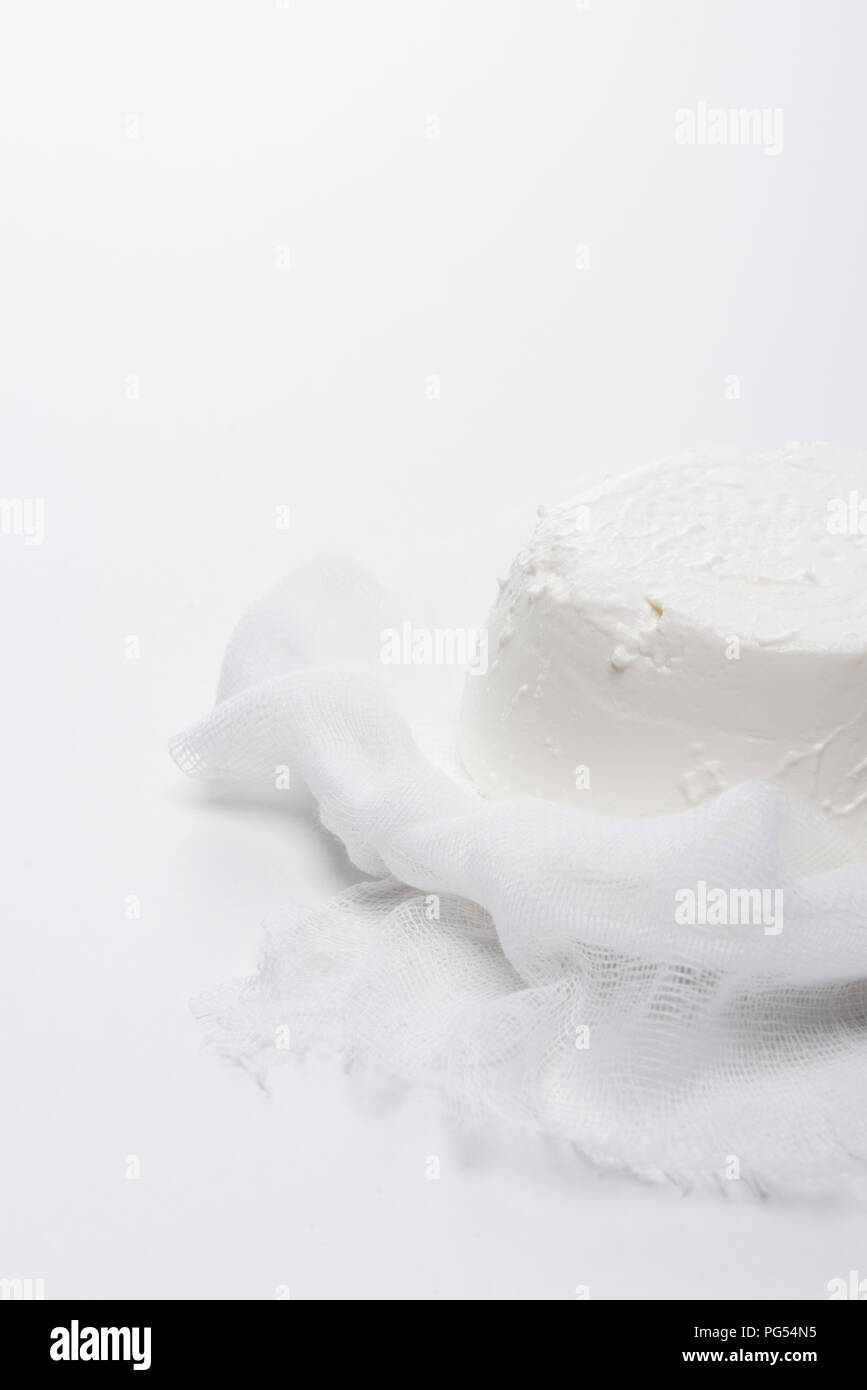 close-up shot of creamy cottage cheese on cheesecloth on white surface ...