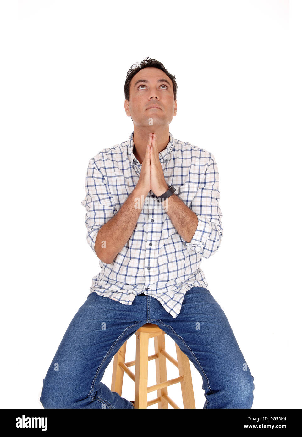 A tall handsome man sitting on a chair and folding his hands and ...