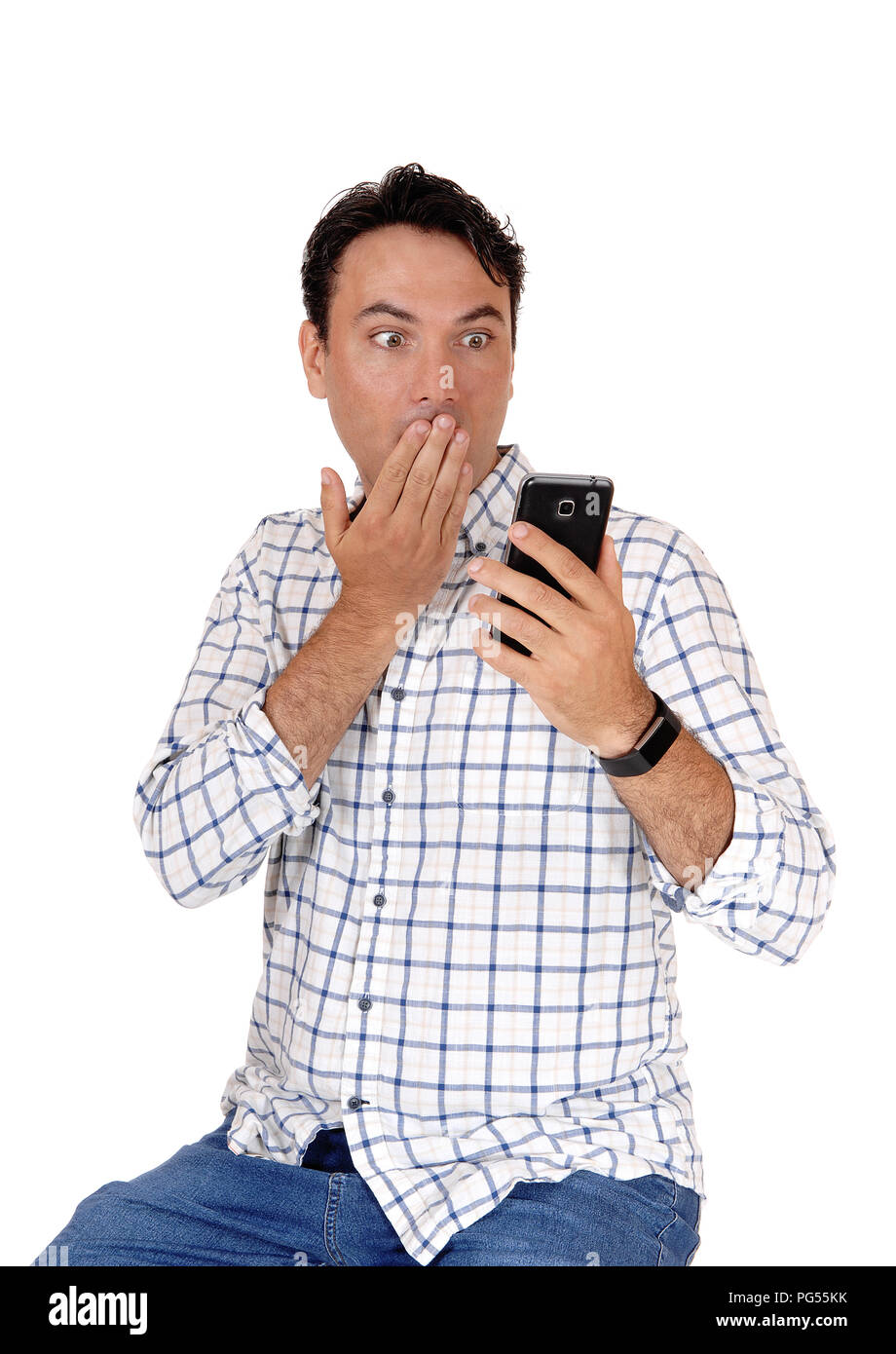 A young man holding up his phone, looking very scared what is on his ...
