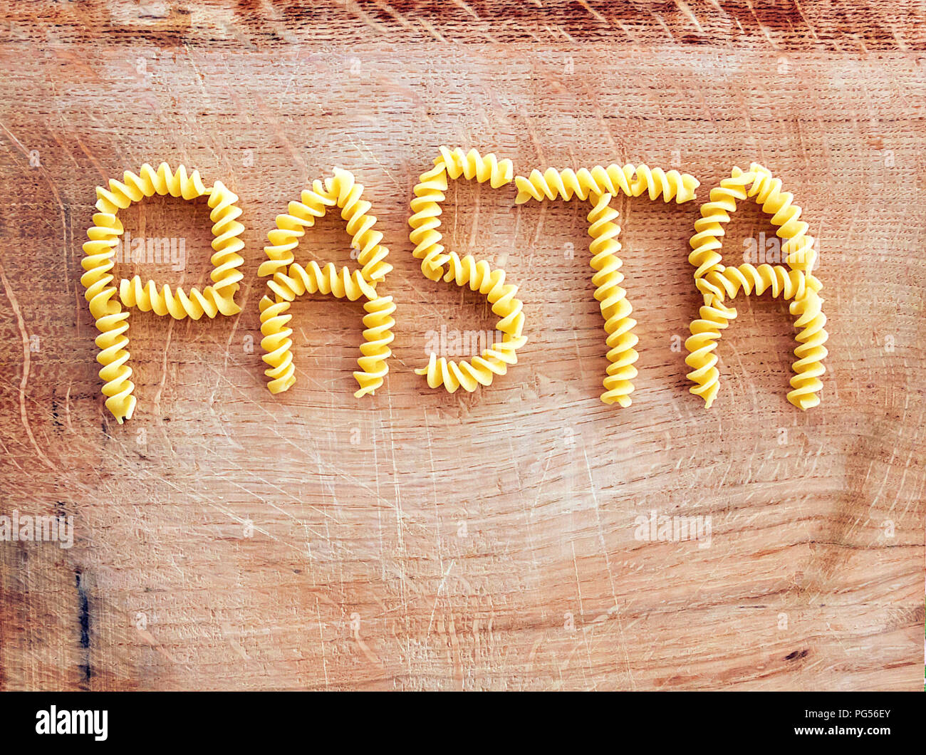 PASTA word done with pasta fusilli on a wooden chopping board Stock ...