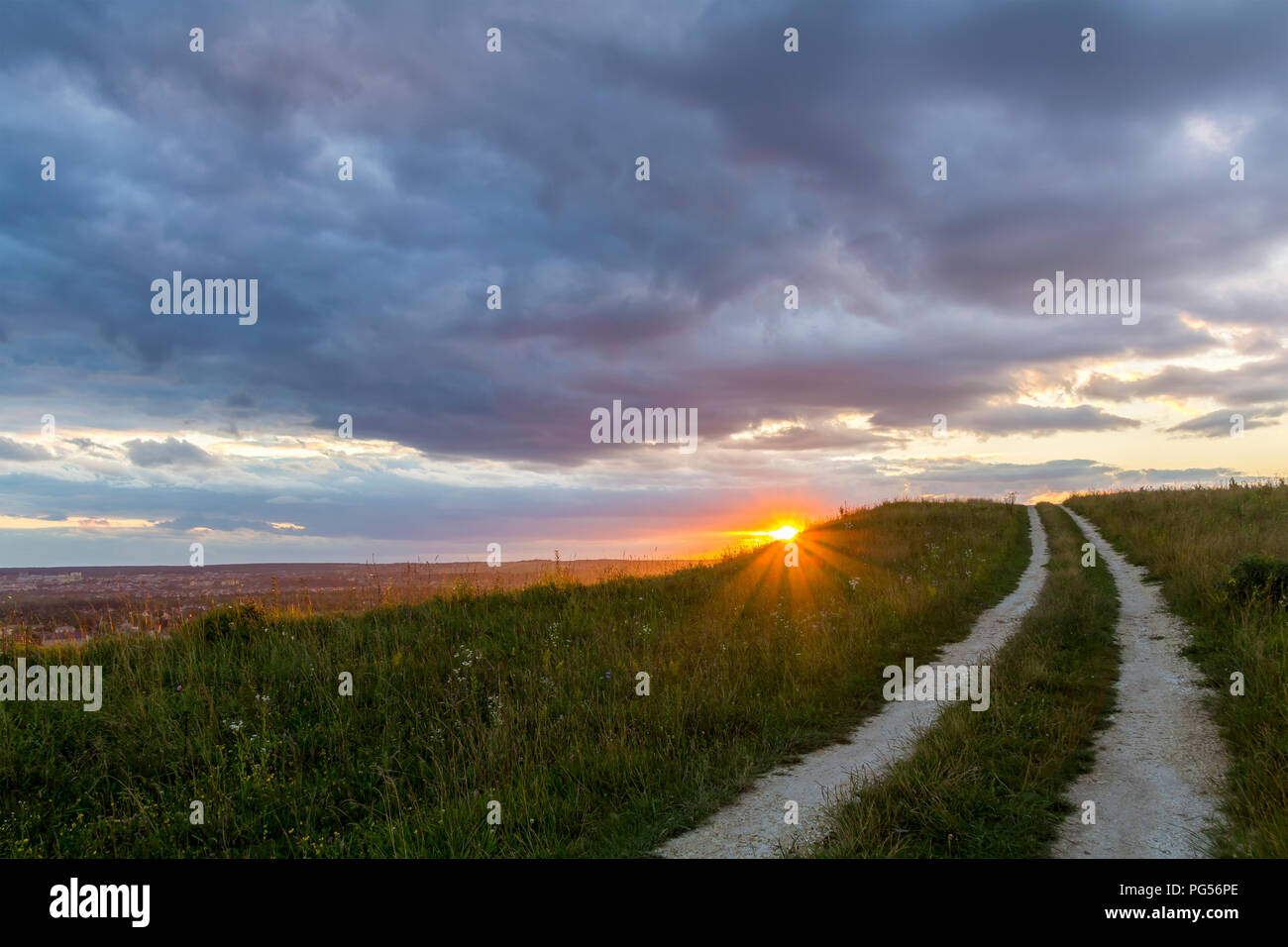 Beautiful landscape at sunset or sunrise, narrow ground road stretching ...