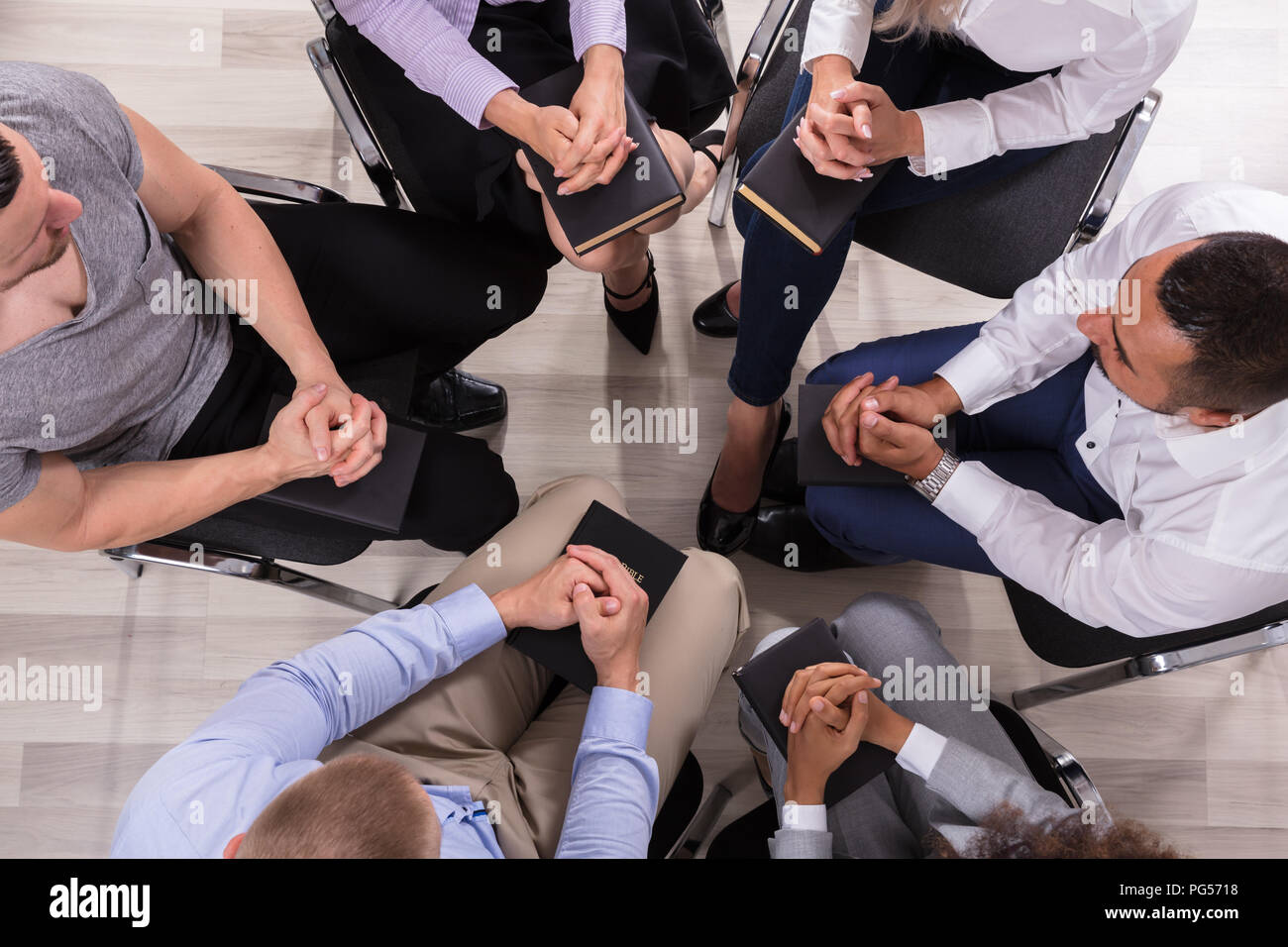 Elevated View Of People With Holy Book Praying Together Stock Photo - Alamy