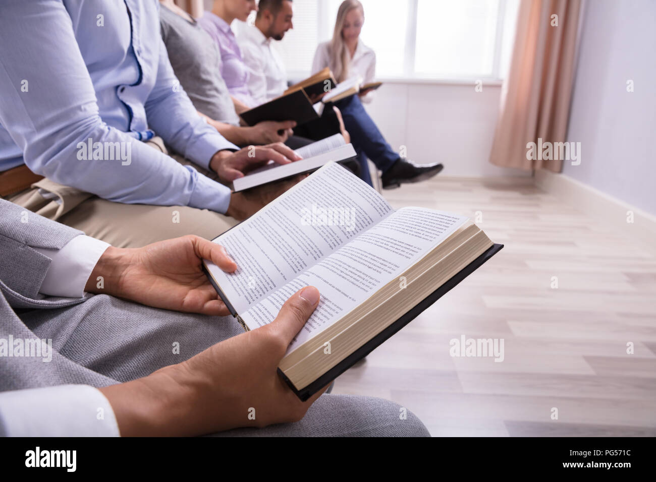 Mid Section View Of People Reading Holy Book In Hall Stock Photo - Alamy