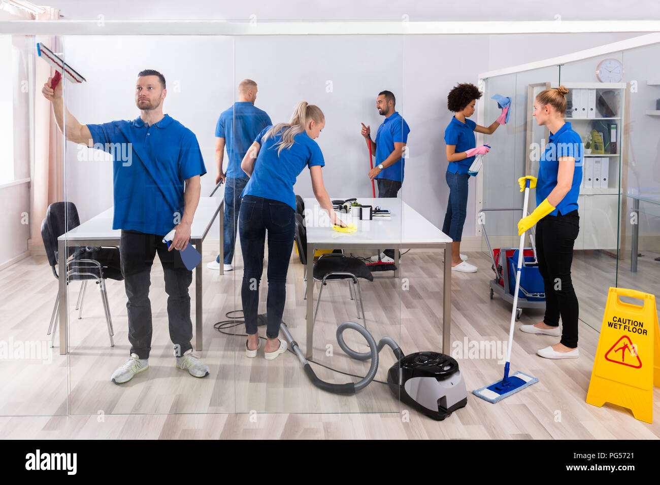 Group Of Skilled Young Janitors In Uniform Cleaning Office Stock Photo ...