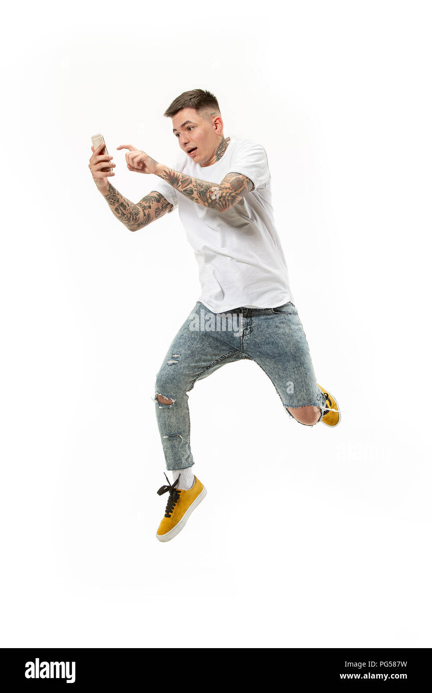 always on mobile. Full length of handsome young man taking phone while ...