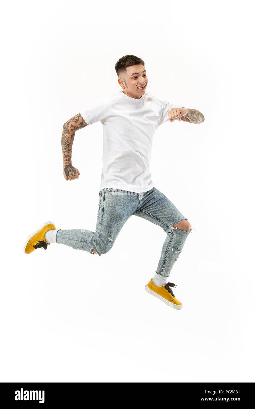 Freedom in moving. Mid-air shot of handsome happy young man jumping and ...