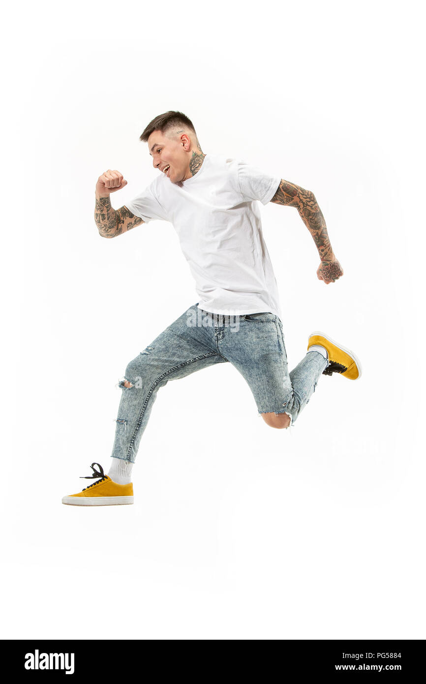 Freedom in moving. Mid-air shot of handsome happy young man jumping and ...