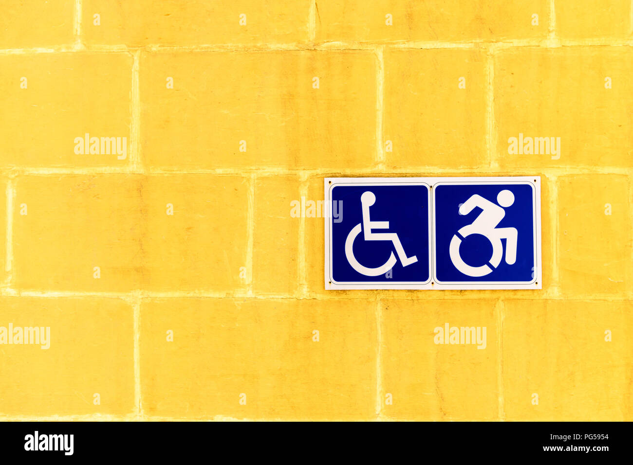 Wheelchair access sign on a yellow wall Stock Photo - Alamy