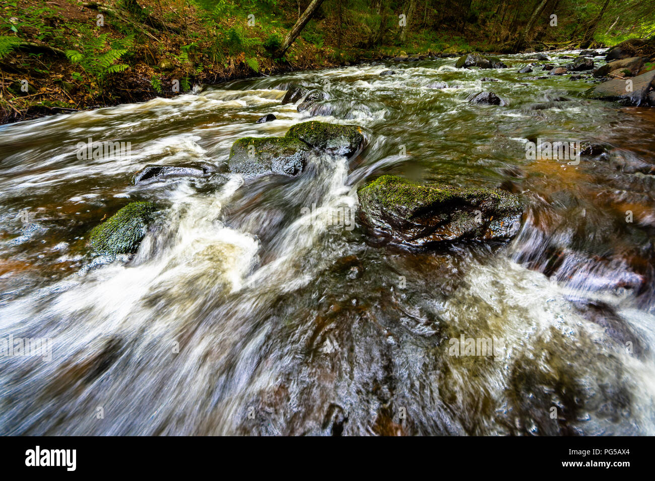 Rushing stream over boulders Stock Photo - Alamy