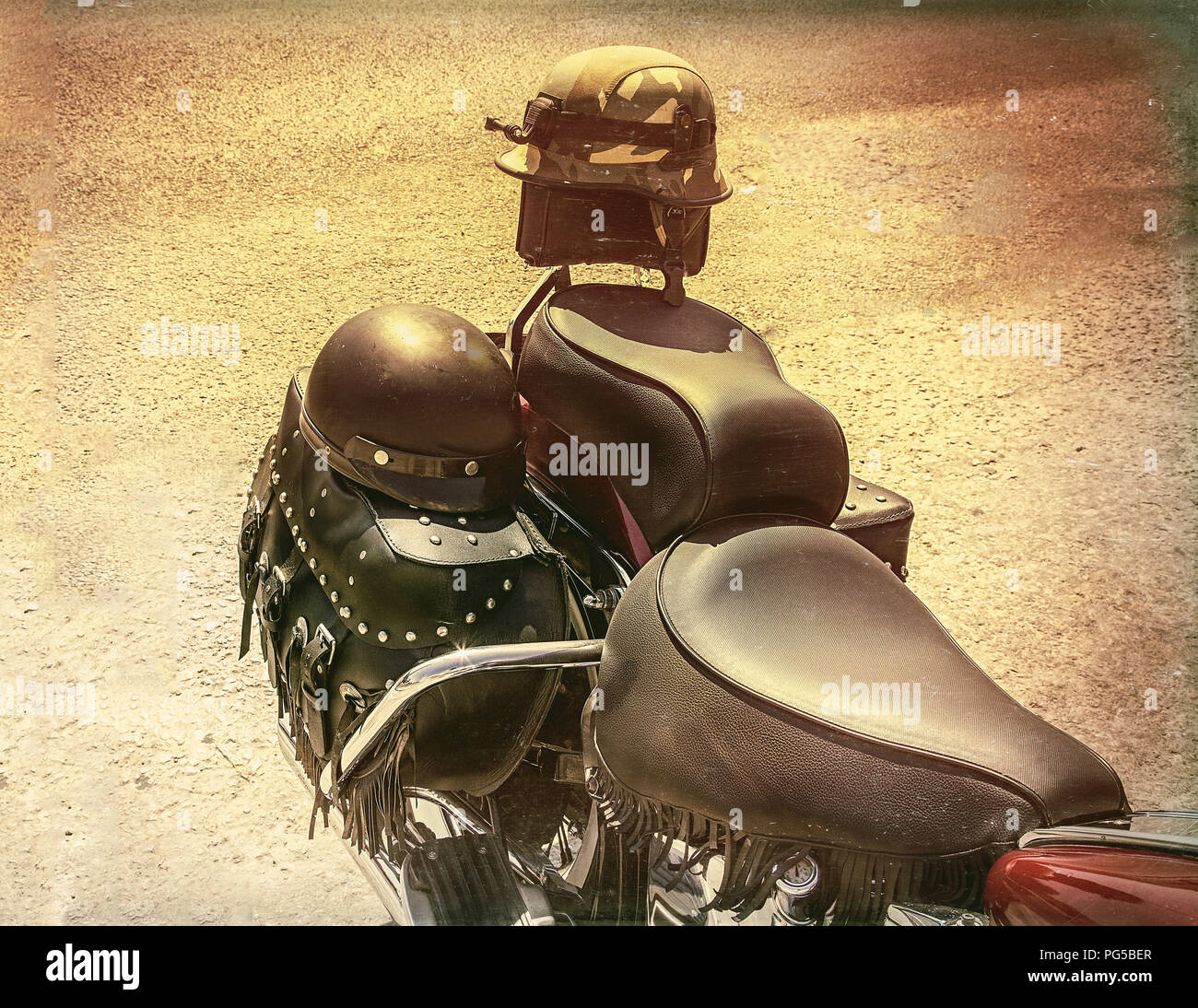 Two crash helmets for him and her on the back of a classic motorbike ...