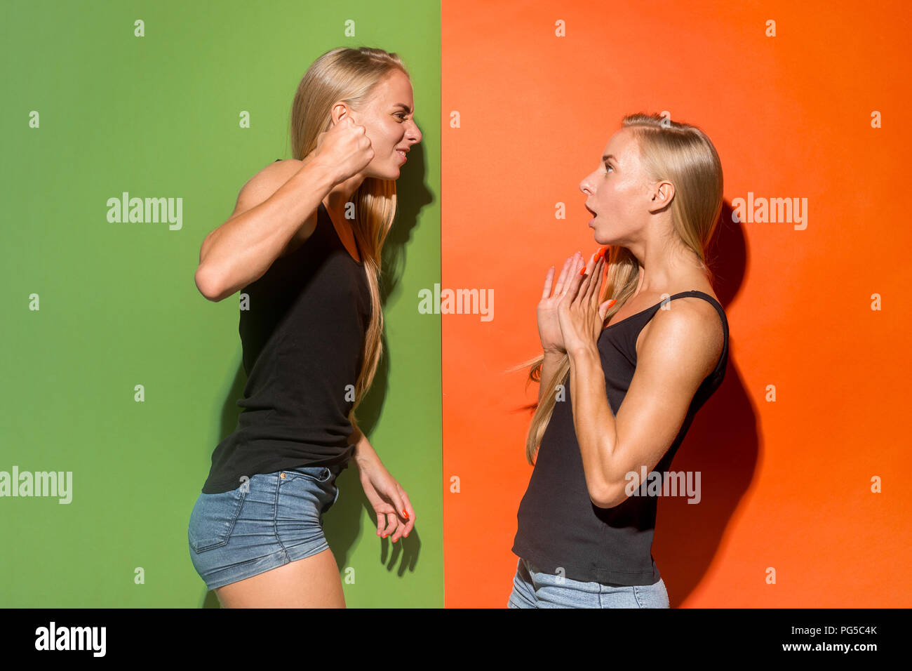 Angry women. Aggressive women standing isolated on trendy studio ...