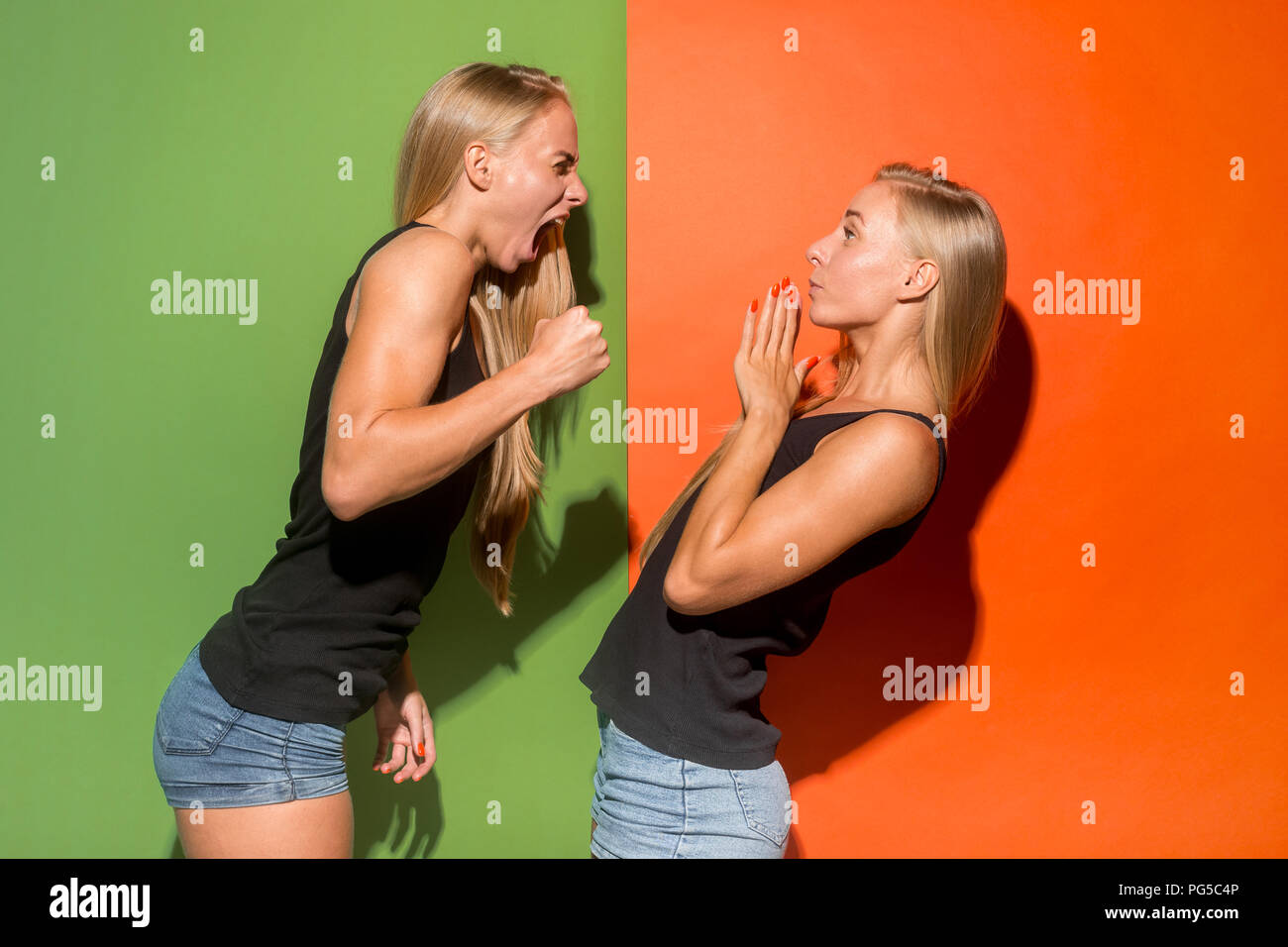 Angry women. Aggressive women standing isolated on trendy studio ...