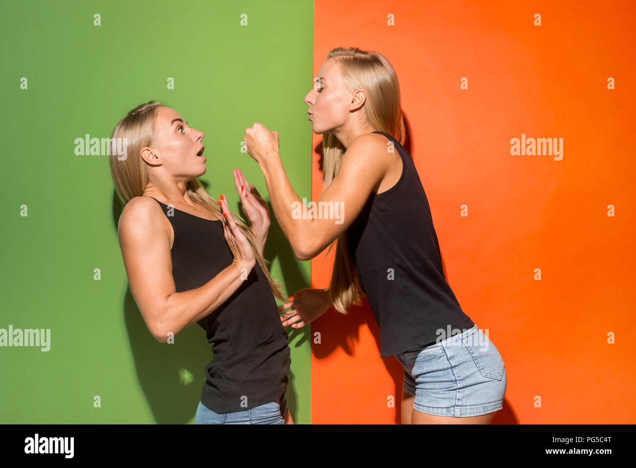 Angry women. Aggressive women standing isolated on trendy studio ...