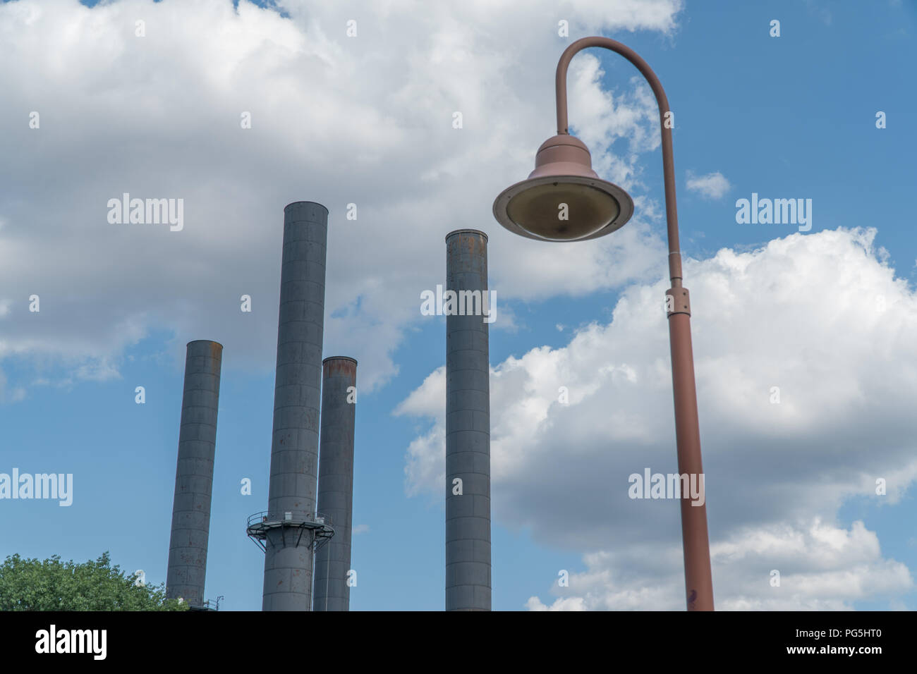 View looking at old factory smoke stacks with antique lamp post in ...