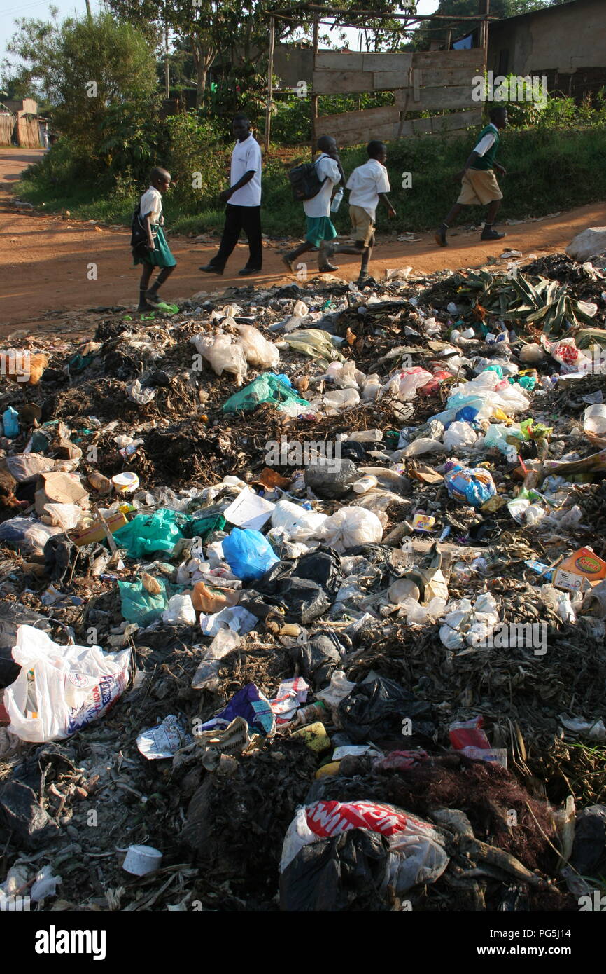 School children and pedestrians walk past garbage that is dumped by the ...