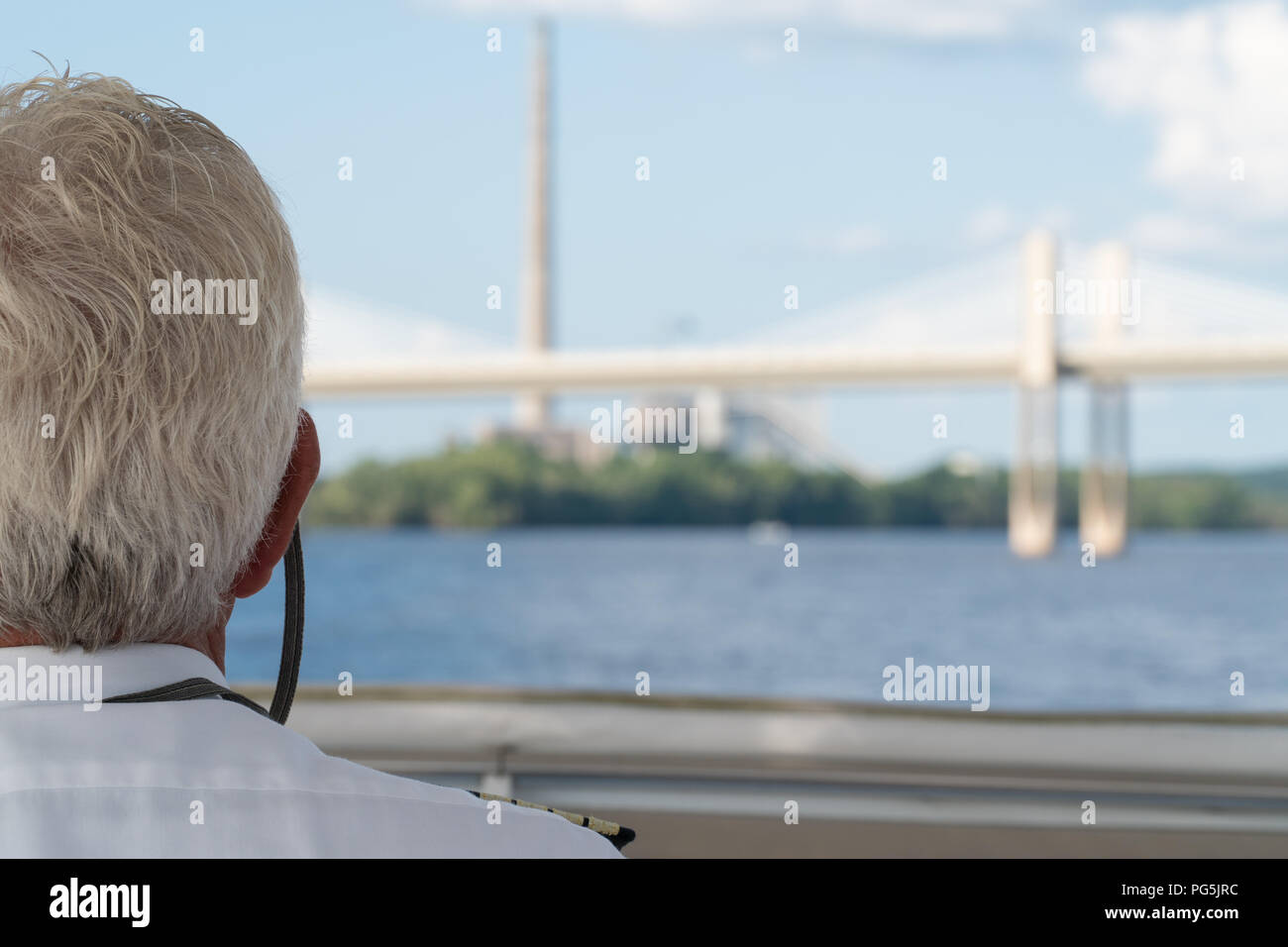 POV over the shoulder view of boat captain sailing down a river towards ...