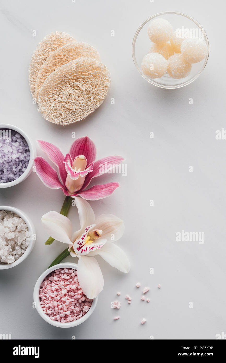 beautiful orchid flowers, sea salt in bowls and sponges on white ...