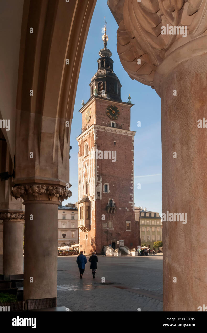 The town hall tower framed by the central market columns of Krakow ...