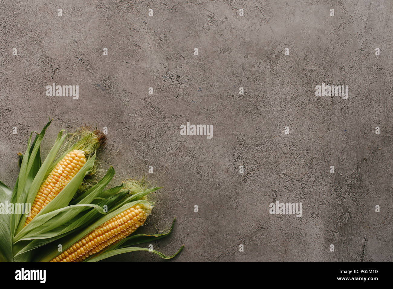 top view of raw corn cobs on grey concrete surface Stock Photo - Alamy