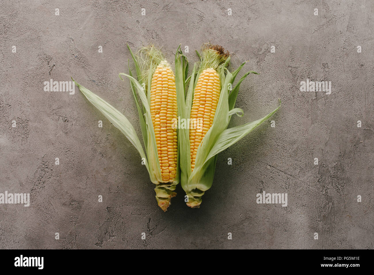 top view of raw corn cobs on grey concrete surface Stock Photo - Alamy