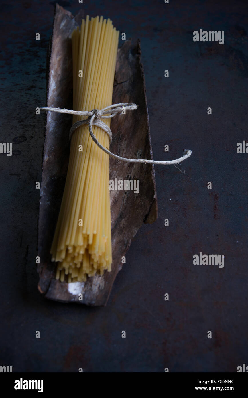 Isolated whole wheat dry spaghetti on rustic background- traditional ...