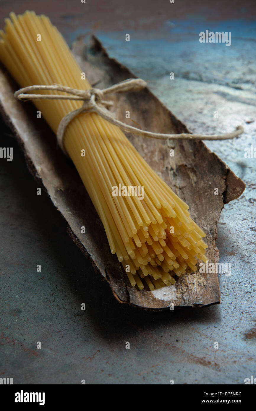 Isolated whole wheat dry spaghetti on rustic background- traditional ...